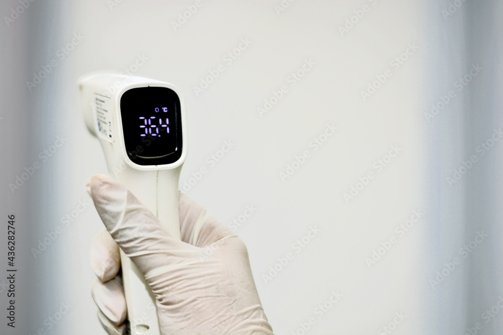 Non contact infrared forehead digital thermometer held by a medical ...