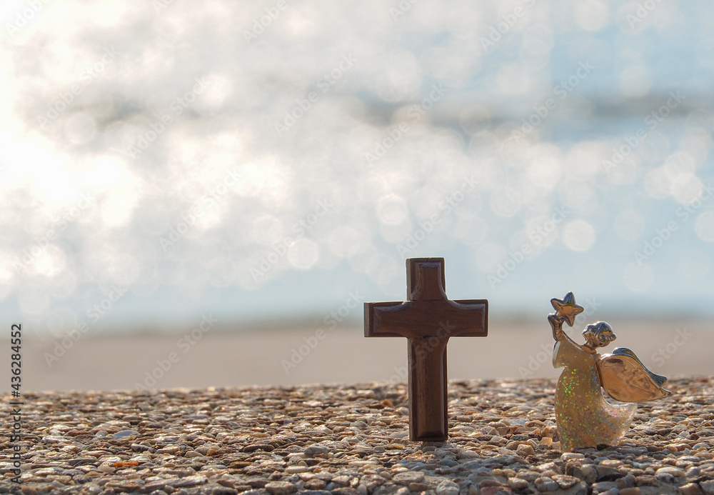 Angel shape on gravel floor in bokeh of sea .Angel and miracle. Faith ...