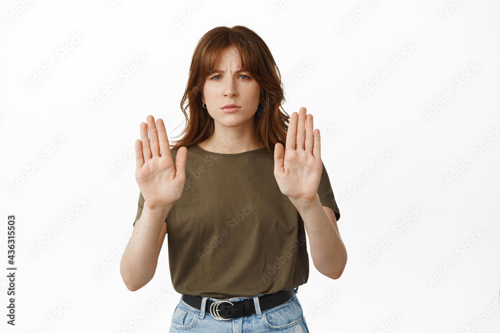 Stop, dont come closer. Serious young woman extend hands, show block ...
