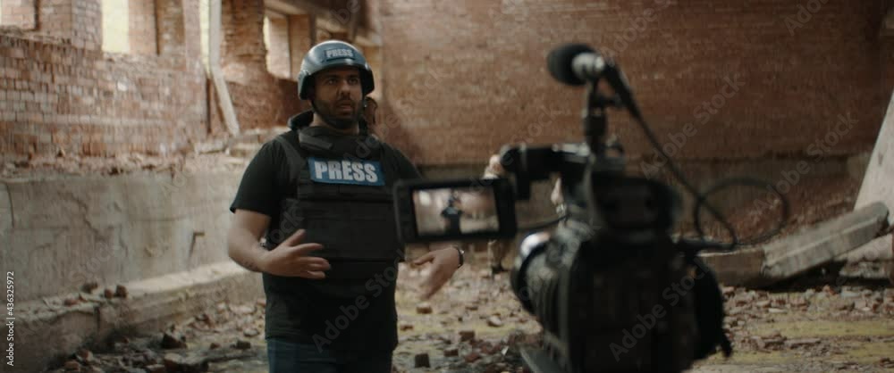 HANDHELD Behind the scenes of war journalist correspondent wearing ...