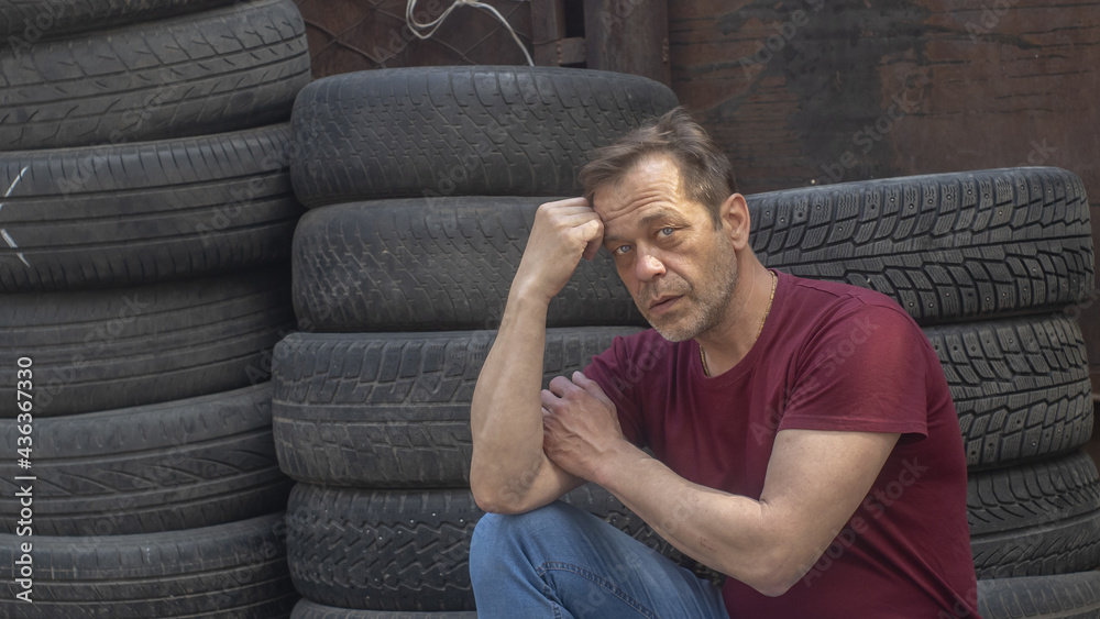 Portrait of a thoughtful and tired elderly man 45-50 years old sitting ...
