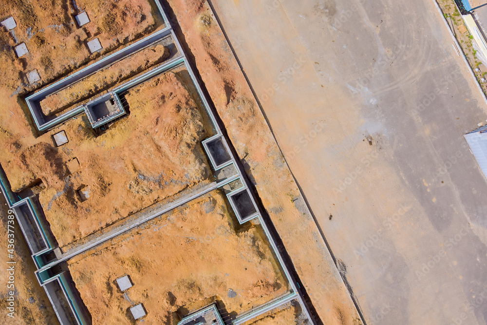 Building site of trenches dug in ground and filled with cement as ...