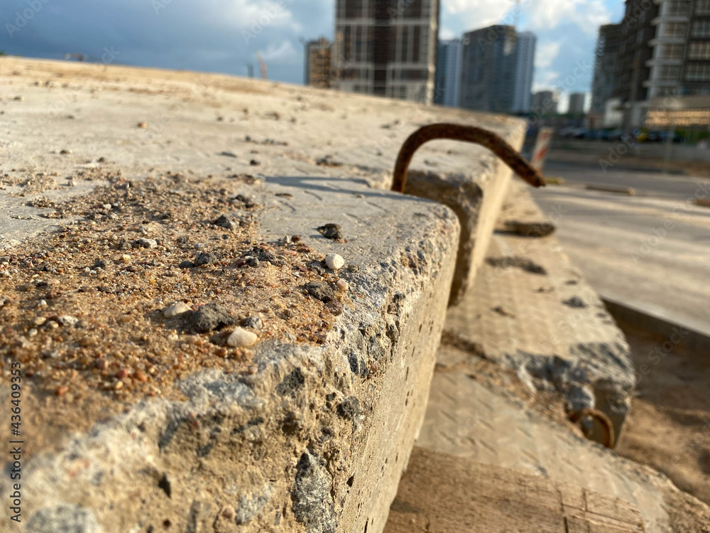 Selective focus, cement slabs at construction site, rusty steel rebars ...