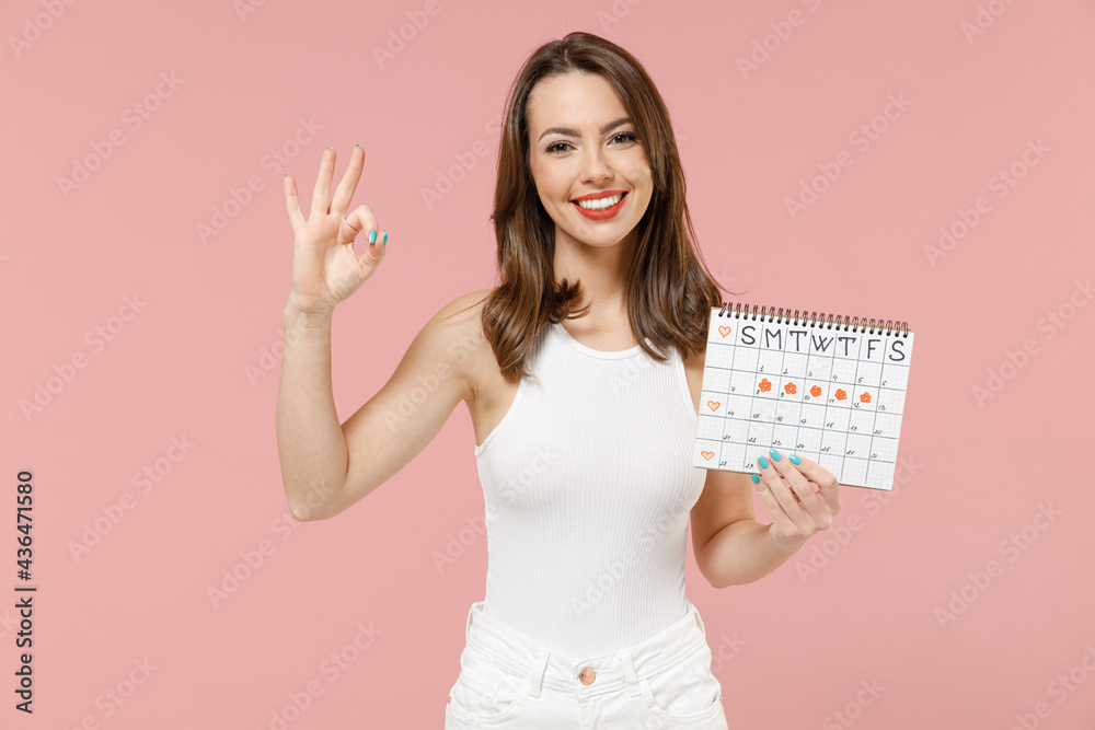 Young happy woman in white clothes hold female periods calendar for ...
