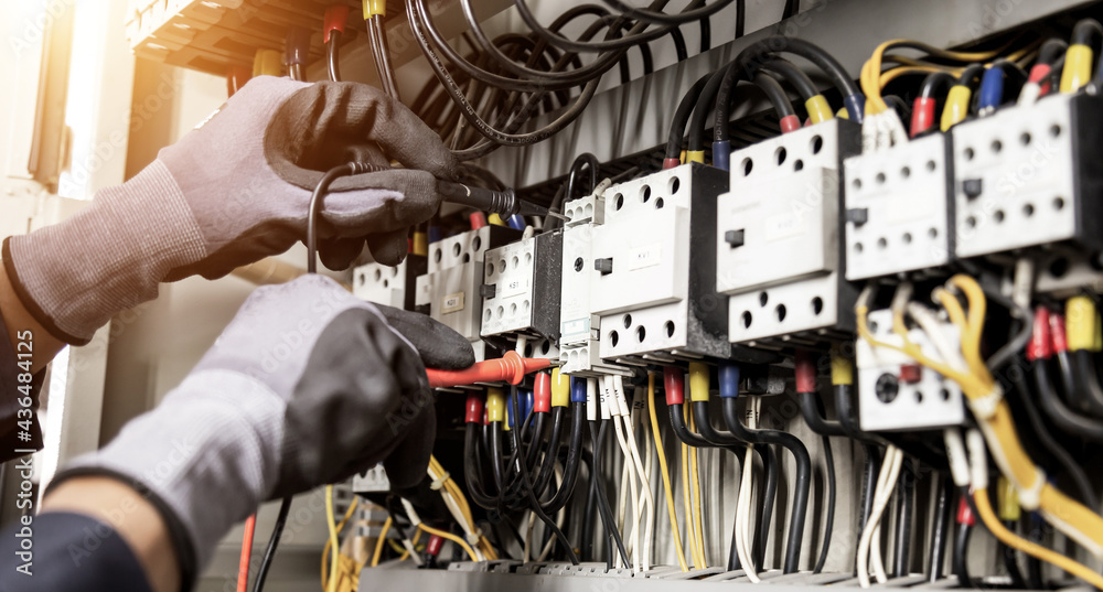 Electrician engineer tests electrical installations and wires on relay ...