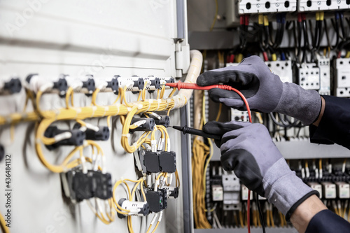 Electrician engineer tests electrical installations and wires on relay ...
