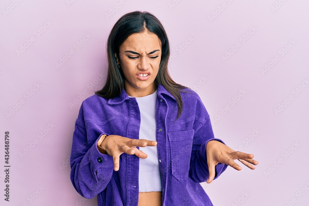 Young brunette woman wearing casual clothes disgusted expression ...