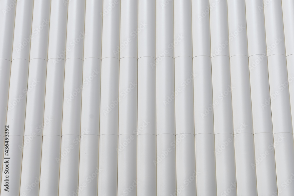 circular metal structure made of several white tubes as a cladding for ...