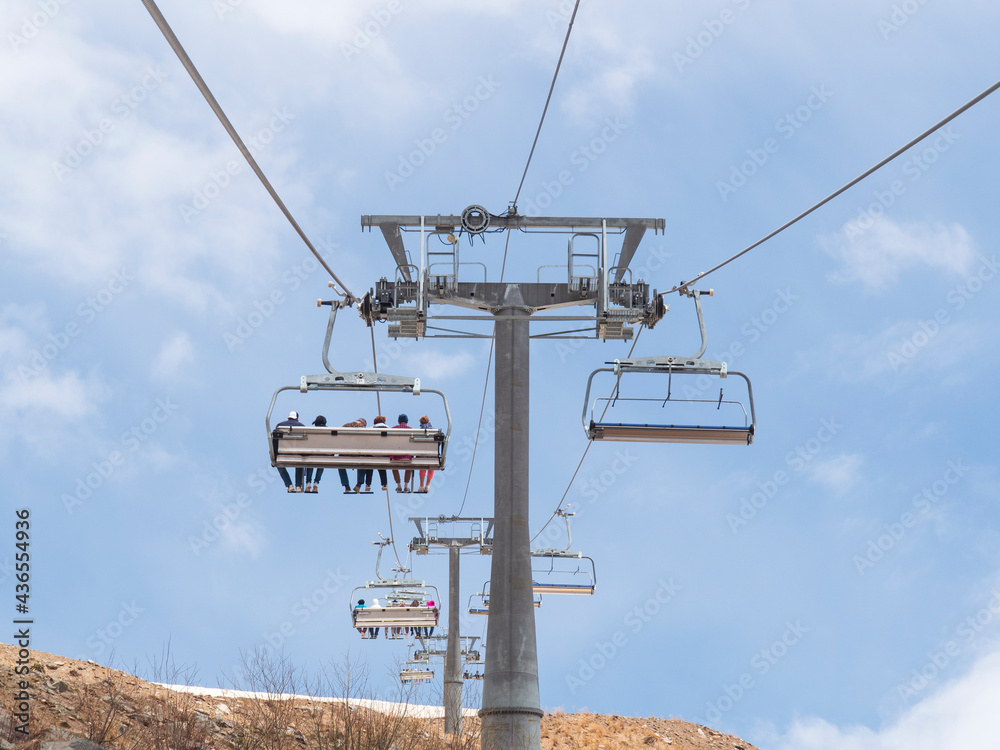 Open cable car, chairlift with empty seats on the background of a blue ...