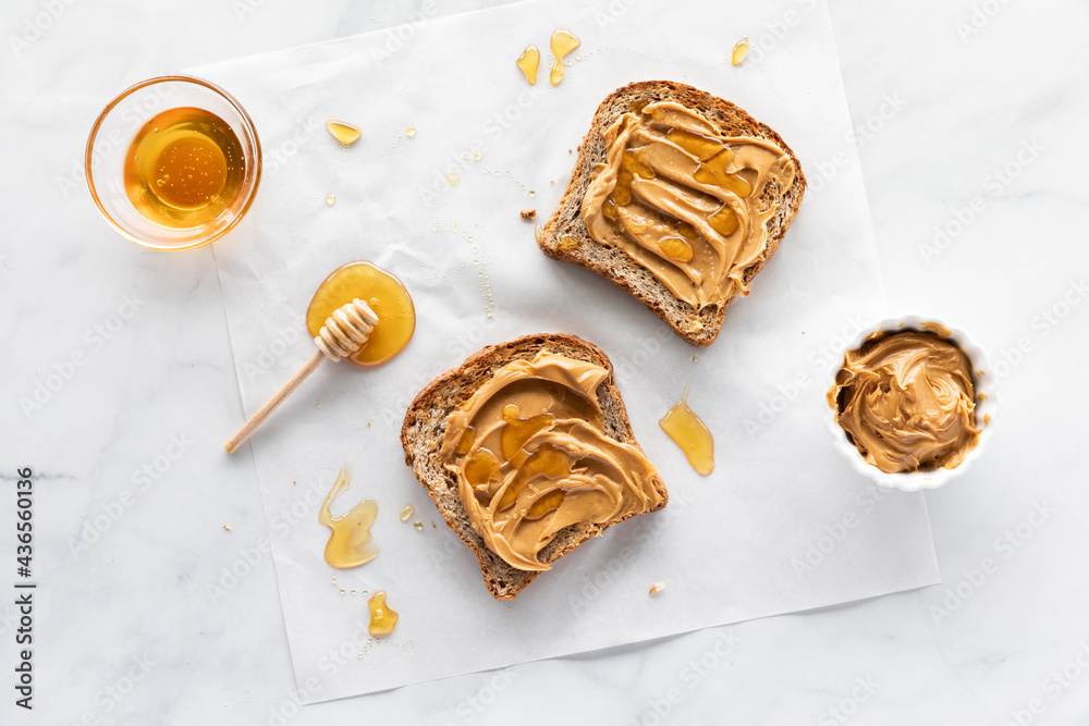 Two pieces of toast with peanut butter and honey spread on top and a ...