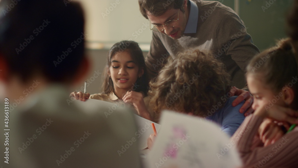 Teacher talking with students at round table in classroom. Pupils ...
