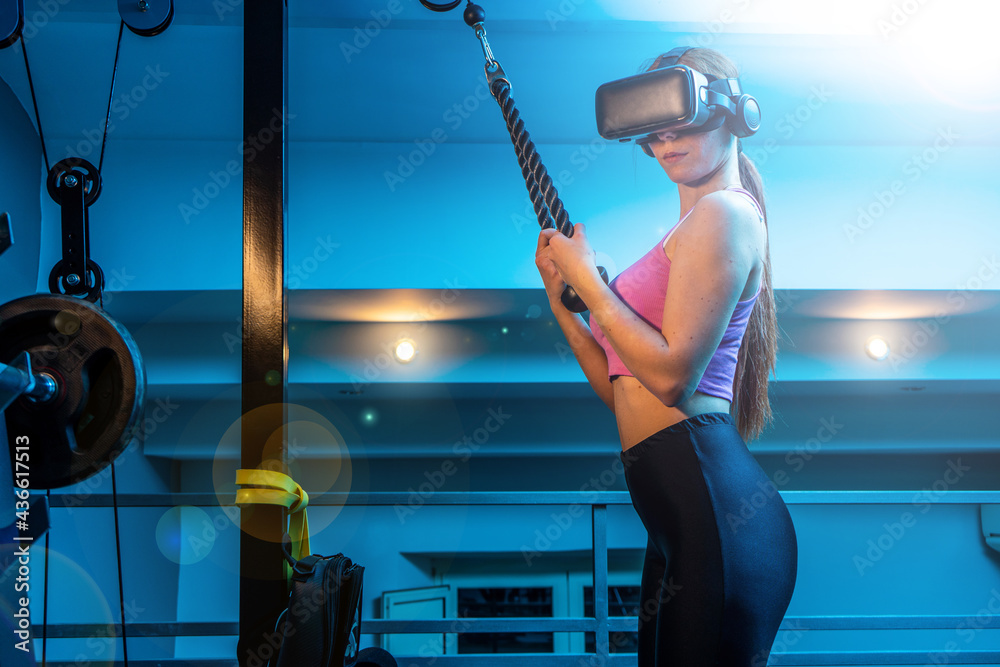 Attractive young red hair sportswoman training triceps in the gym of ...