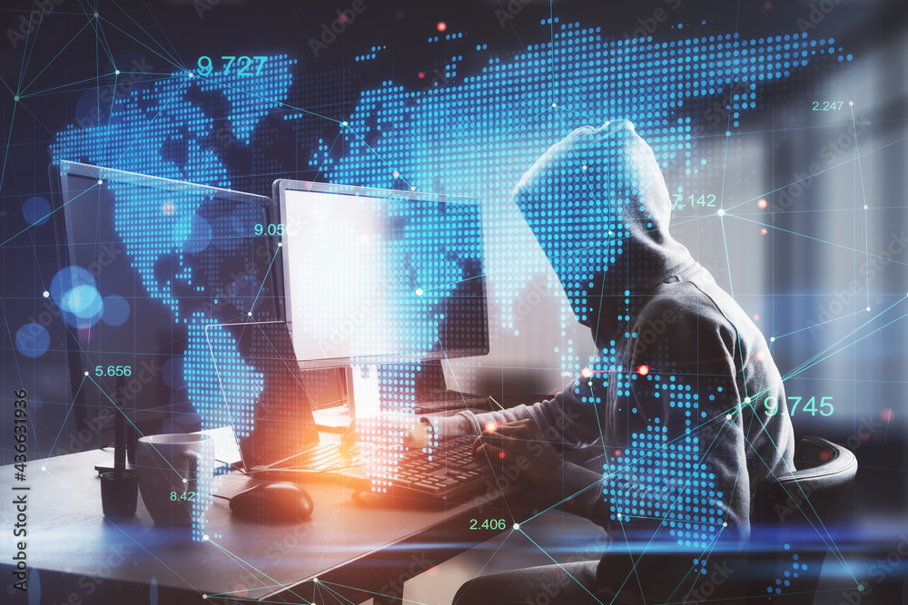 Hacker at desktop using laptop with digital map in blurry office ...