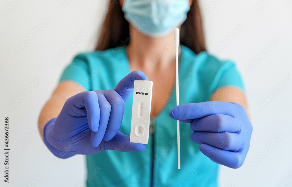 Close-up image of doctor holding covid rapid antigen test and swab ...