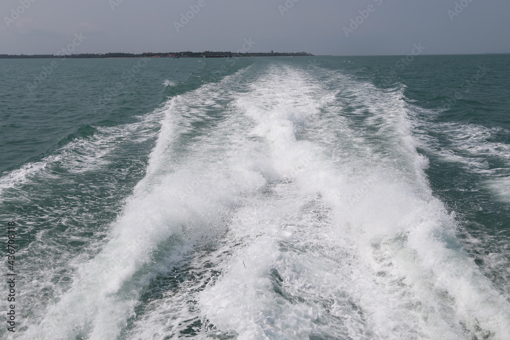 Ship wake on the ocean.aves from the back of a speed boat over the ...