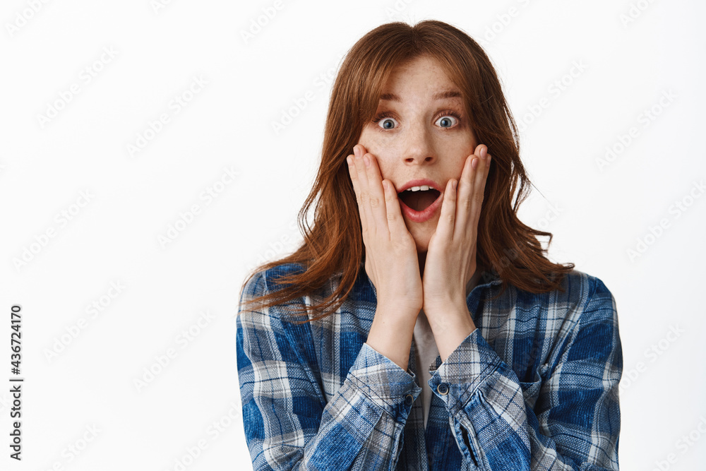 Surprised and excited ginger girl stare in awe, drop jaw and gasping ...