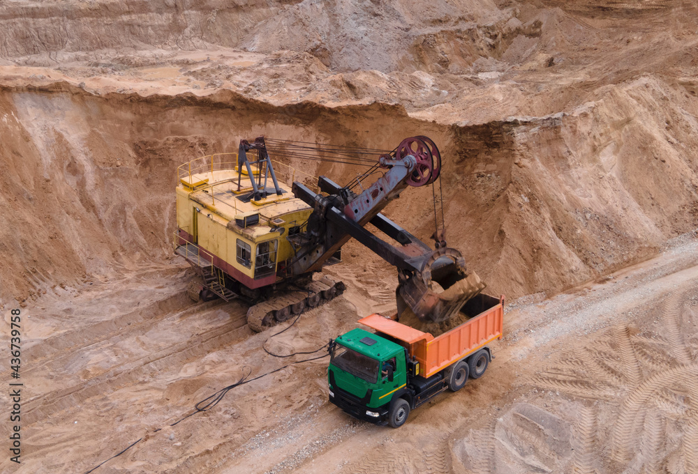 Largest mining excavator with electric shovel loading sand into dump ...
