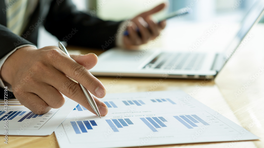 Businessmen analyze financial statistics with graphs and charts and ...