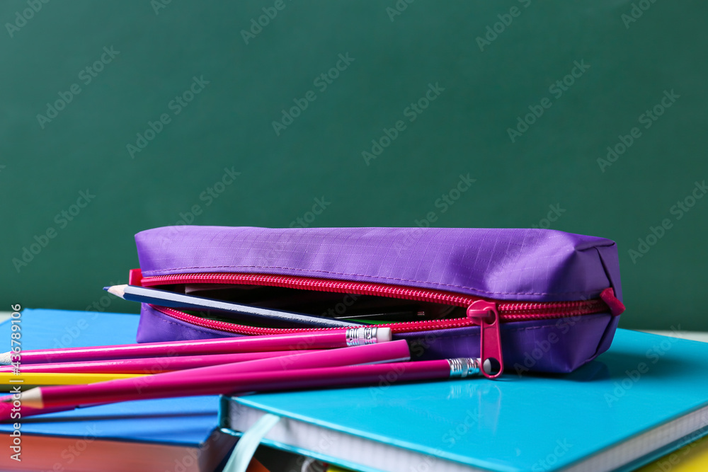 Pencil case with stationery on color background Stock Photo | Adobe Stock