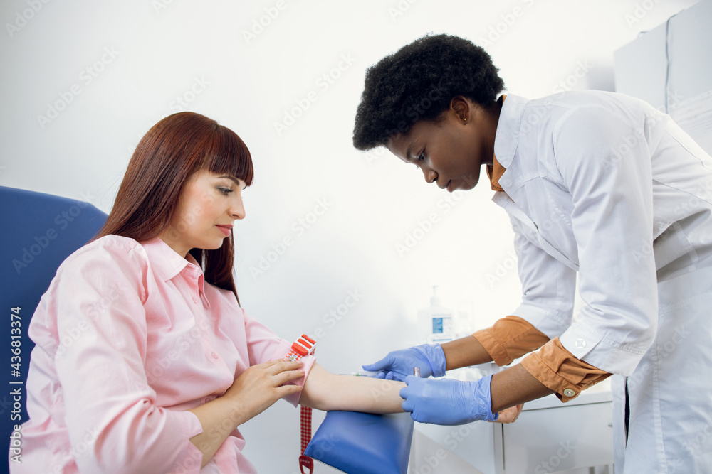 Preparation for blood test. Beautiful young African woman doctor in ...