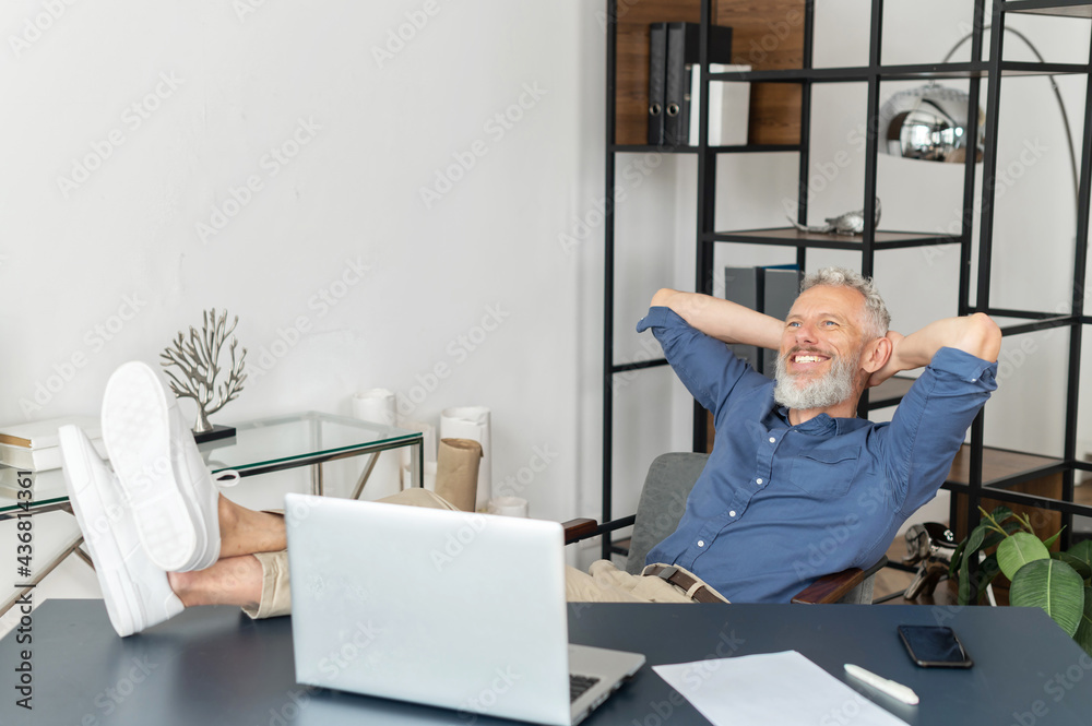 Successful senior man ceo rests on his workplace, contemporary ...