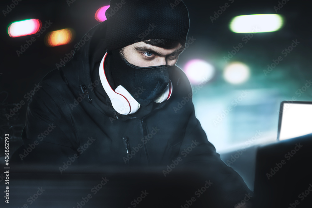 Angry computer hacker weared balaclava stealing data from laptop in ...