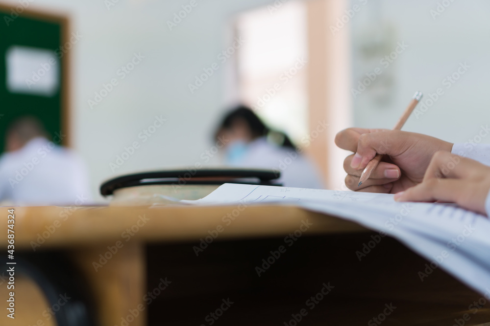 Hand female Asian students taking exam test and concentration reading ...