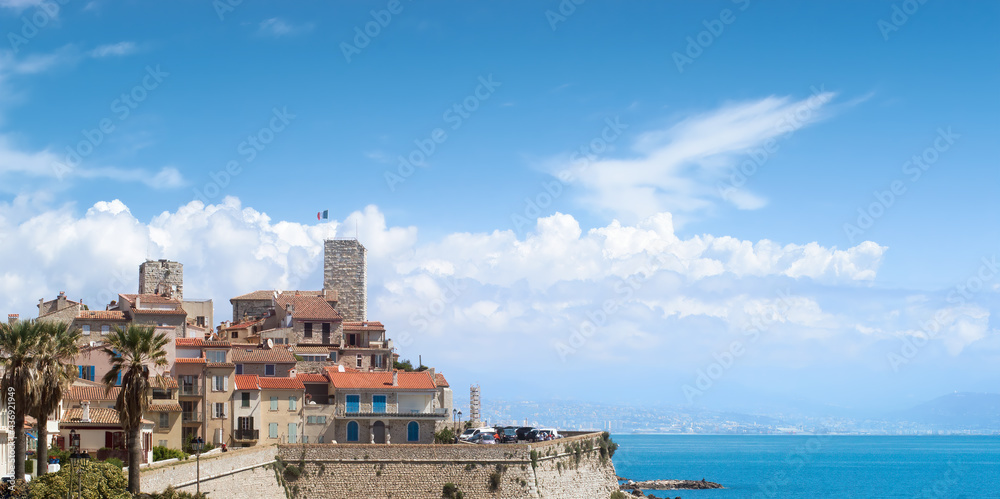 Old city of Antibes, palm trees, tower, rampart and blue mediterranean ...