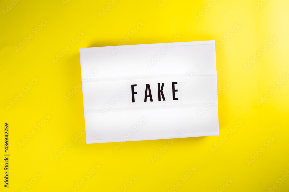 Lightbox with text message FAKE isolated on yellow background. Concept ...
