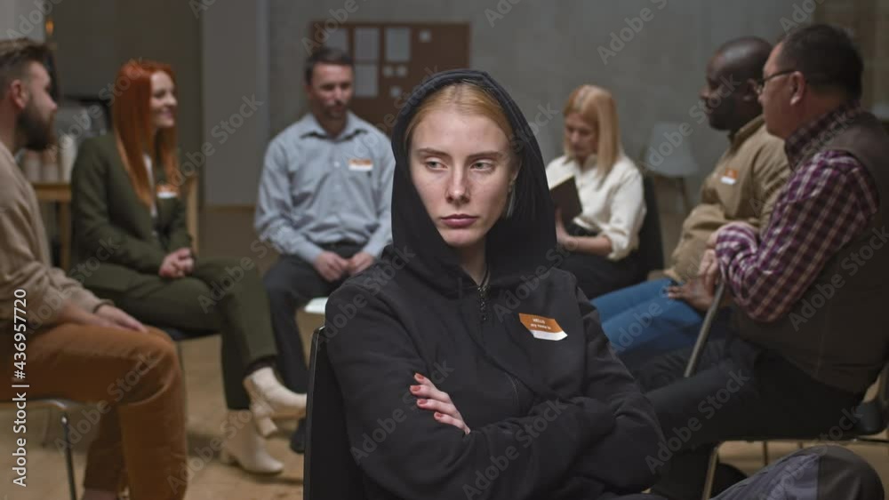 Medium portrait of arrogant young woman looking indifferently at camera ...