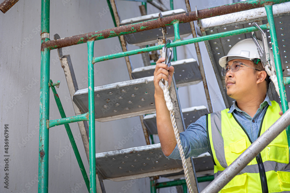 Engineer working on the tall buildings wear seat belts Safety harness ...