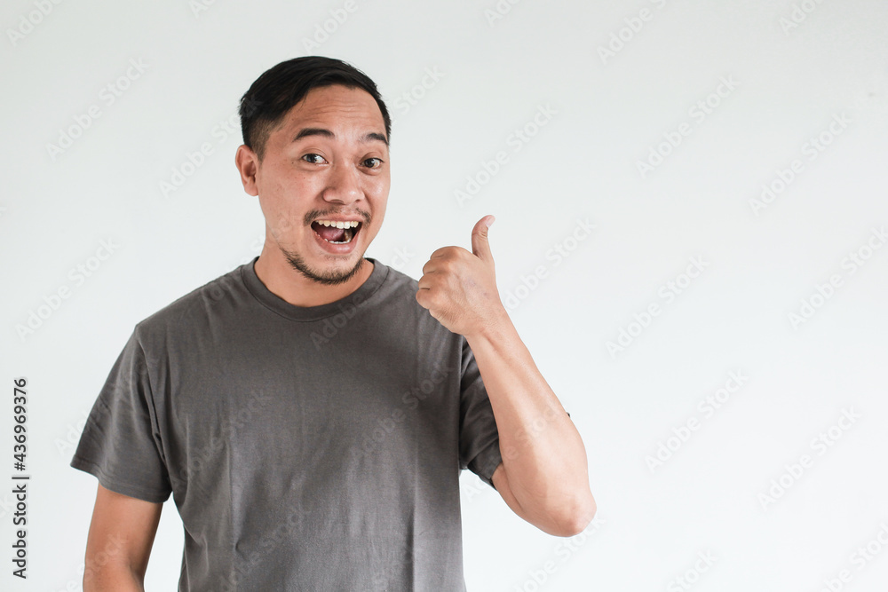 Smile and happy face expression of Asian man point to present an empty ...