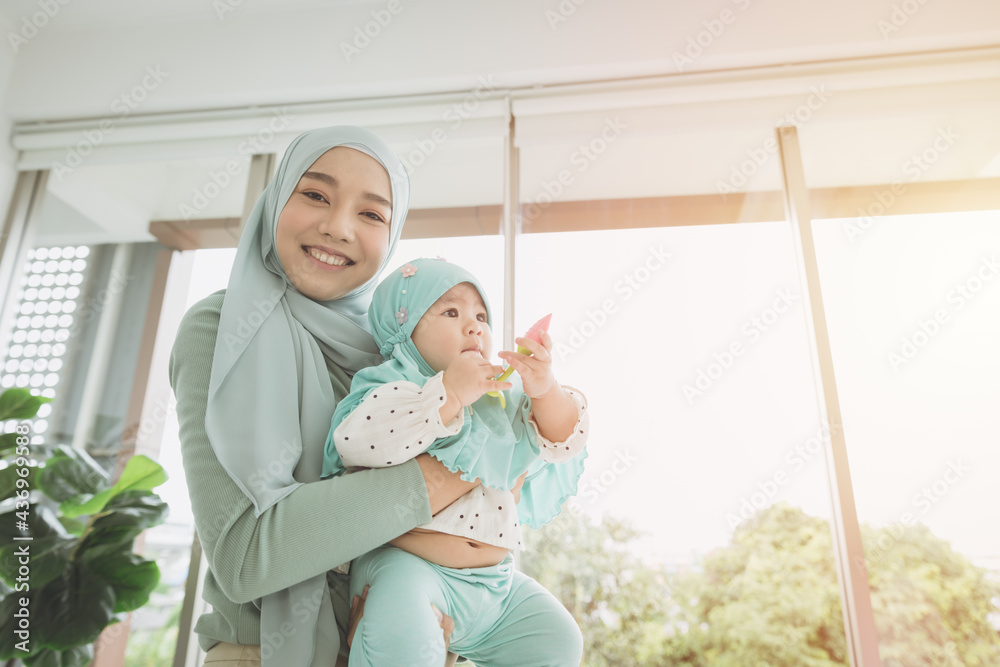 Muslim Hijab holding support her child baby happy smiling at home ...