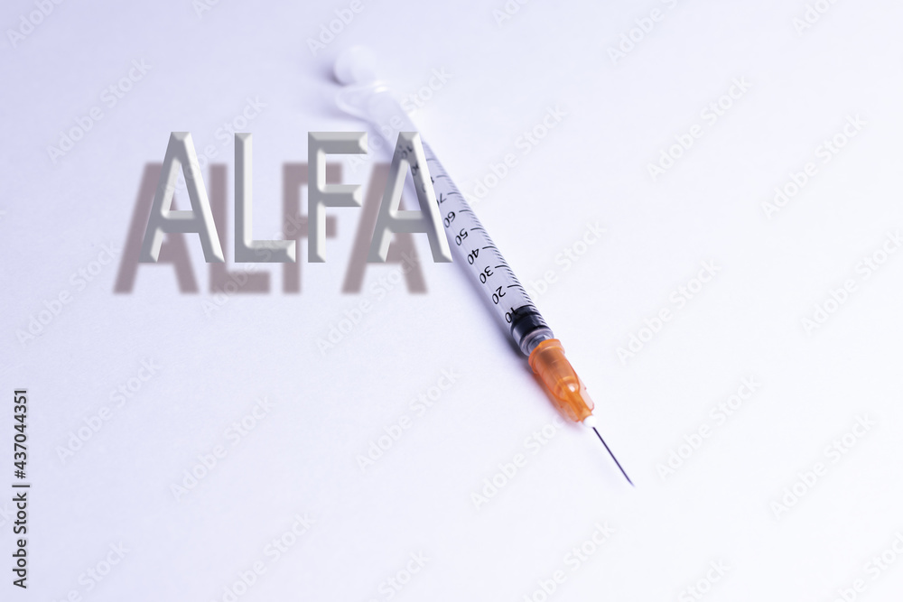Syringe on plain white background with the word alpha written in ...