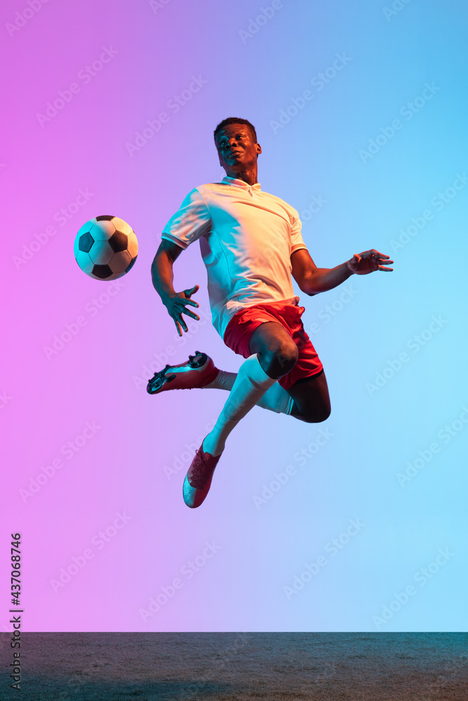 Portrait of African professional football player standing isolated on ...