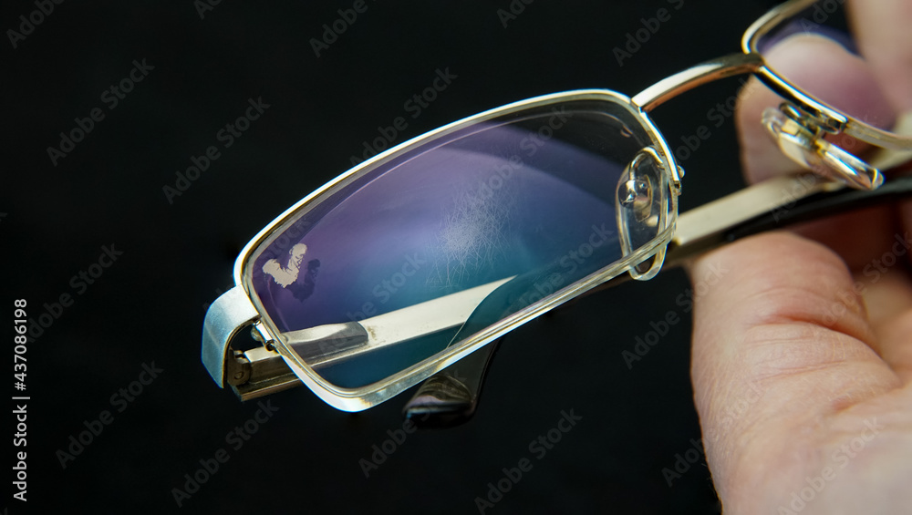 The goggle with scratched lenses. A human hand holds the glasses with ...