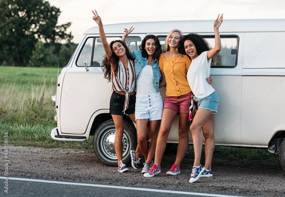 Happy diverse friends at camper van. Four smiling women standing ...