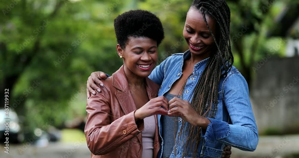 Friends making heart symbol together standing outside, african women ...