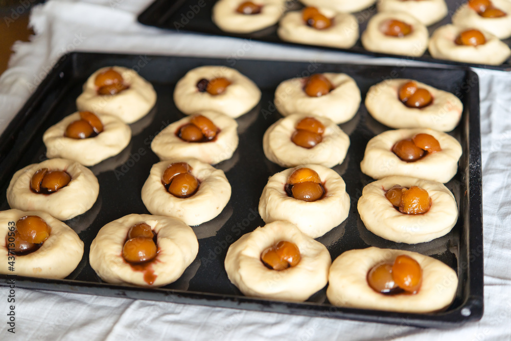 Stages of cooking yeast buns with jam and fruit. Stage 3 - adding fruit ...