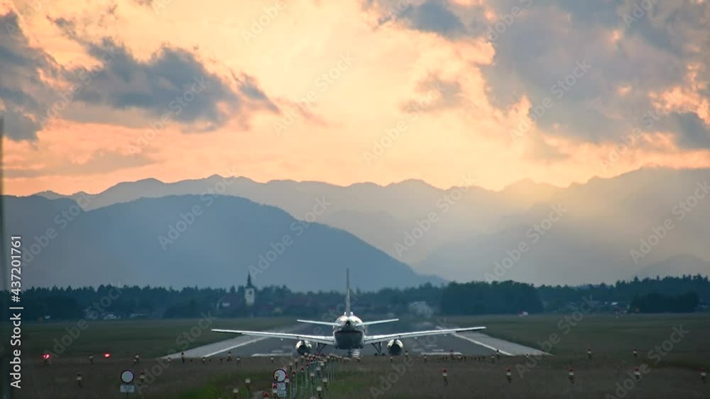 Large passenger aircraft taking off against beautiful sunset at Brnik ...