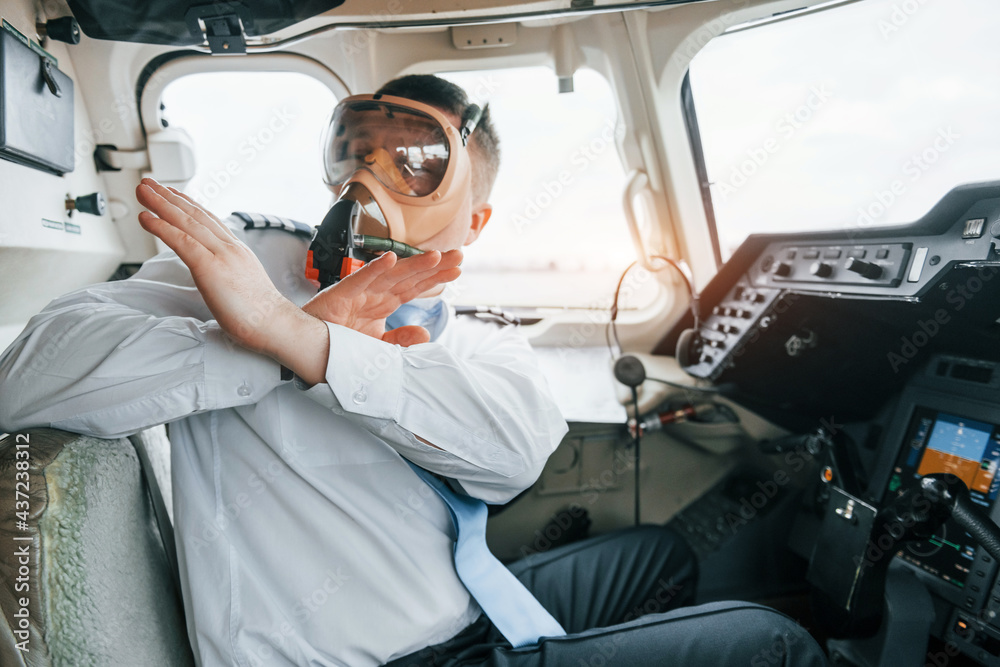 In oxygen mask. Pilot on the work in the passenger airplane. Preparing ...