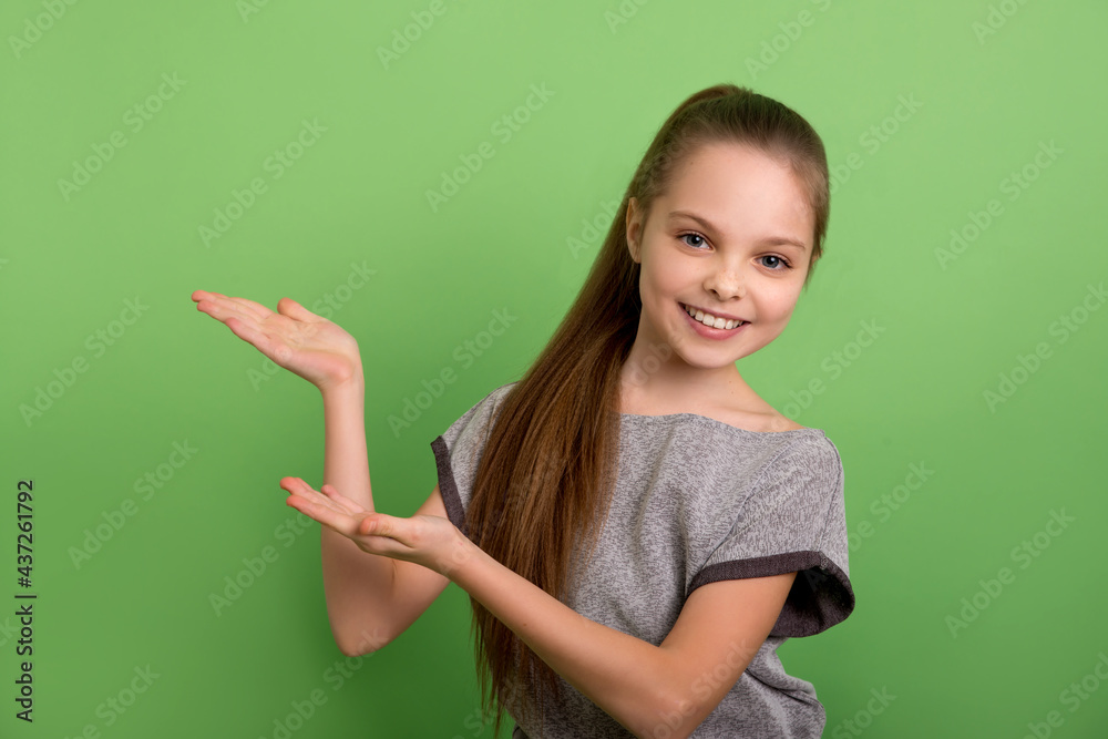 Little teenager smiling girl is showing empty copy space on her open ...