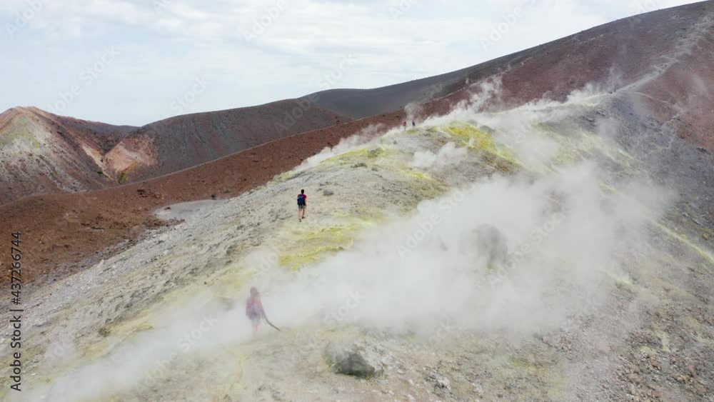 Male and female hikers traveling hiking on volcano, walking trough ...