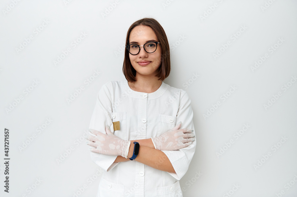 Charming doctor in white medical lab coat poses in front of camera with ...