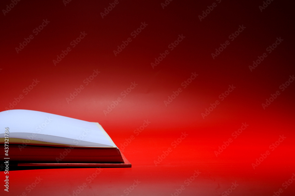 A book that looks like a Bible open in dark and red color background ...