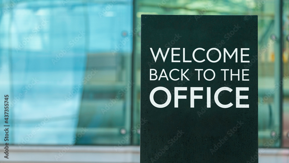 Foto de Welcome back to the office on a sign outside a modern glass ...