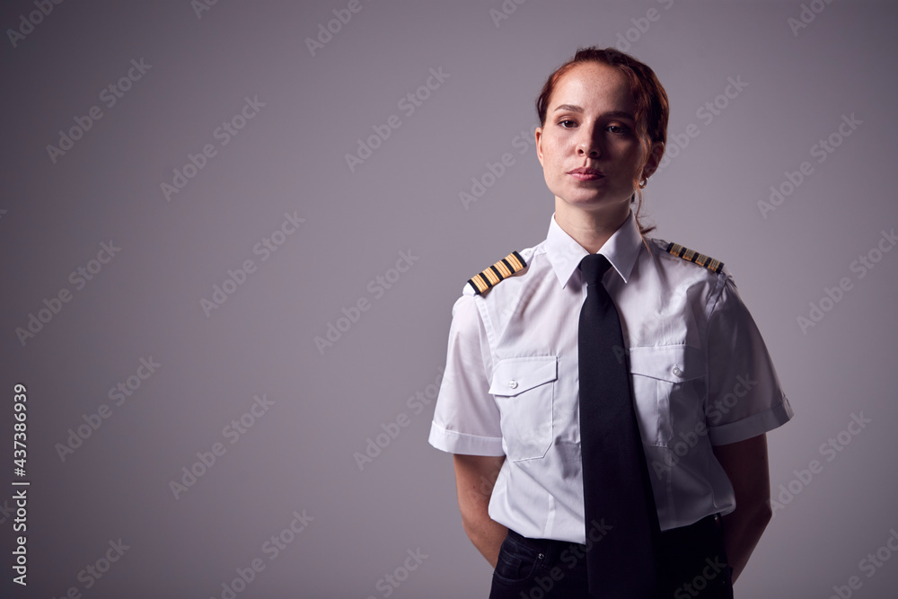 Studio Portrait Of Serious Young Female Airline Pilot Against Plain ...