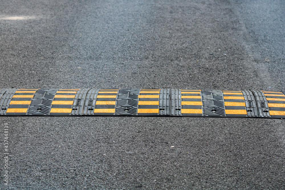 Traffic safety speed bump on an asphalt road in a parking area in ...