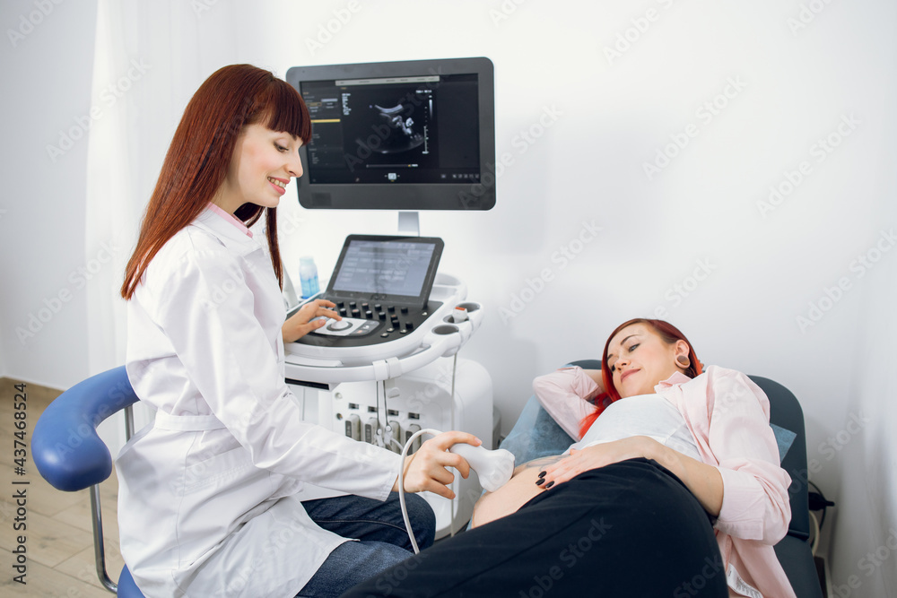 Female happy smiling doctor performs ultrasound examination of her ...