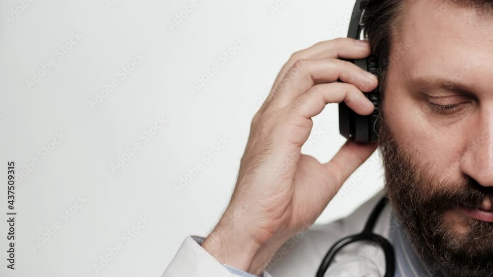 Doctor headphones. Male doctor face on white background, male hand puts ...